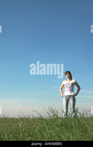 Woman with hands on hip standing on rocks at shore Stock Photo - Alamy