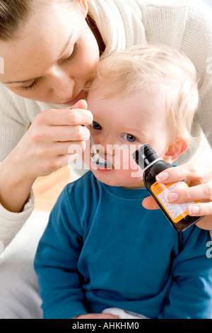 mum giving syrup to her child Stock Photo - Alamy