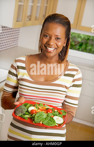 African woman holding plate of vegetables Stock Photo - Alamy