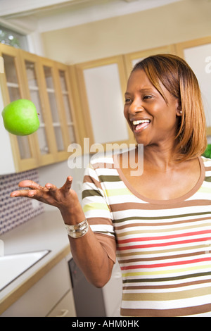 Woman throwing an apple Stock Photo - Alamy