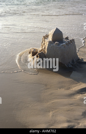 Sand castle washing away Stock Photo - Alamy