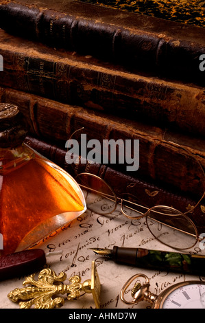 Stack of old books, vintage watch on a desk. Light grey textured ...