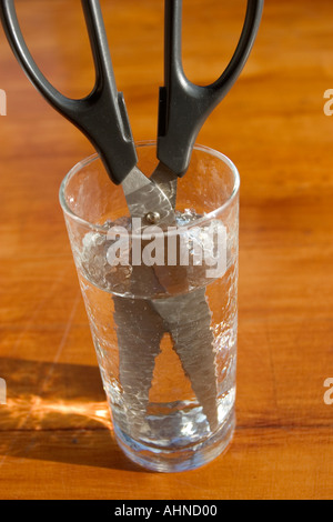 scissor in a full water glass Stock Photo - Alamy
