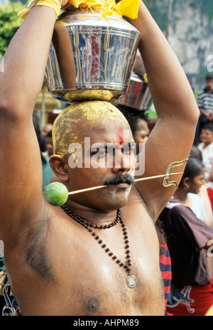 Hindu devotees with metal rods pierced through their tongues walk in a ...
