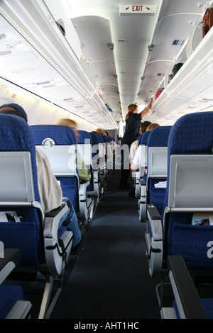 Airplane cabin with passengers, overhead compartments, and a red ...