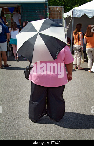 A woman shields herself from the sun with an umbrella as she walks in ...