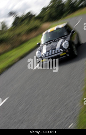 Speeding Mini Cooper on country lane Stock Photo - Alamy