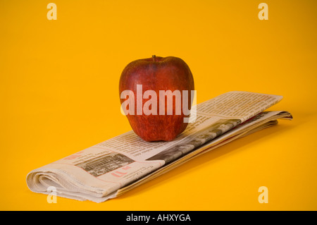 Red apple on newspaper Stock Photo - Alamy