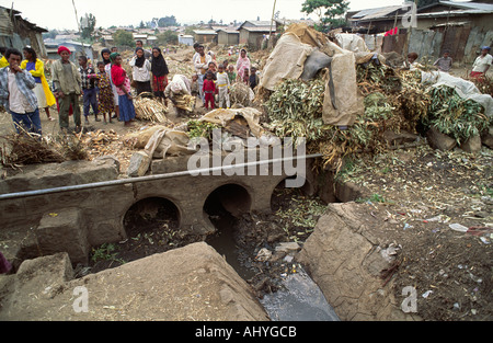 Slum dwellers living in overcrowded, poor housing with open sewers in a ...