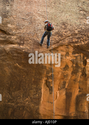 Low angle view of man rappelling from mountain Stock Photo - Alamy