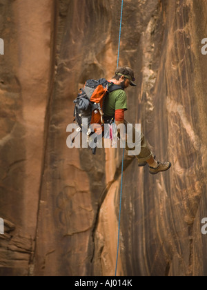 one man rappelling down Looking Glass Arch Stock Photo - Alamy