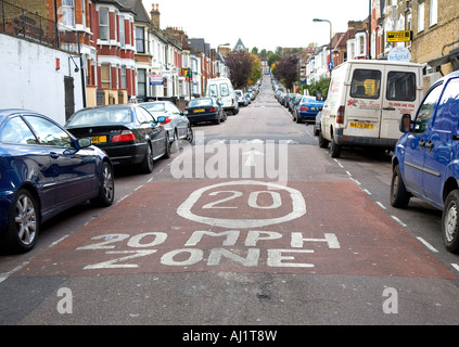 A 20 mph road sign painted on the road in a one way street with a sign ...