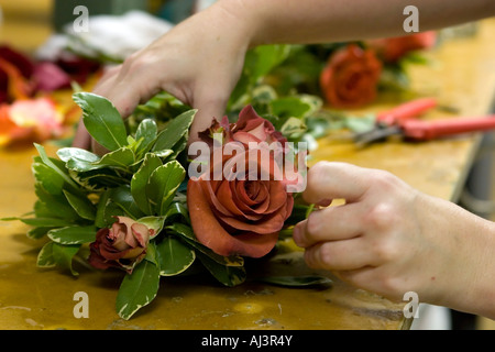 Florist creates rose centerpiece in workroom Stock Photo - Alamy
