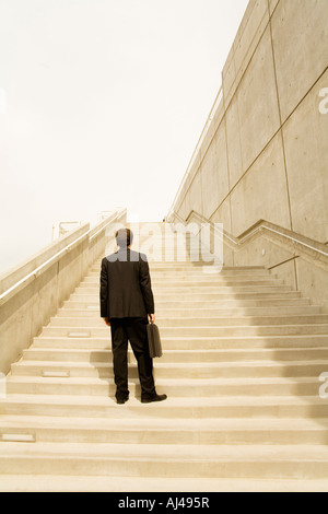 Businessman looking up steps Stock Photo - Alamy