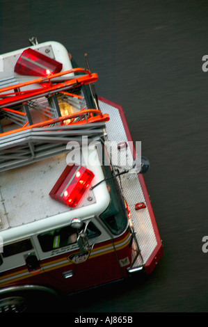 Overhead view of a fireman on a firetruck spraying water from a hose ...
