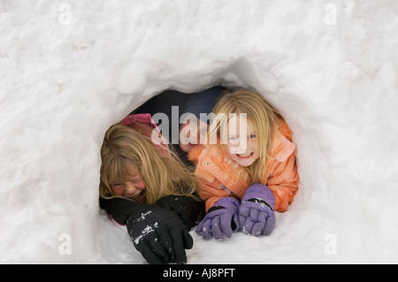 Kids looking into a snow cave Stock Photo - Alamy