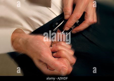 Businessman tightening belt Stock Photo - Alamy