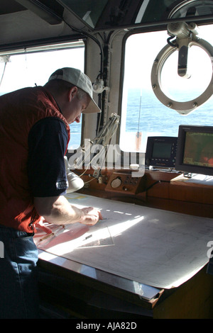 Navigator standing over charts working out the ships course Stock Photo ...