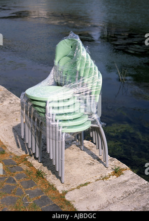 stack of brand new chairs by river bank Stock Photo - Alamy