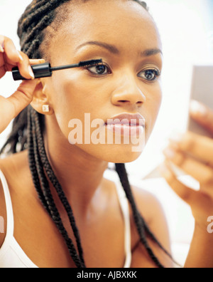 African woman applying make-up Stock Photo - Alamy