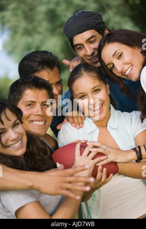 Group of friends playing soccer and fighting over football in grass at ...