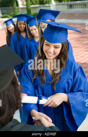 Handshake, graduation diploma and people in success, achievement and ...
