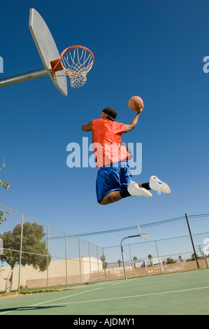 Slam Dunk. Side view of young basketball player making slam dunk Stock ...