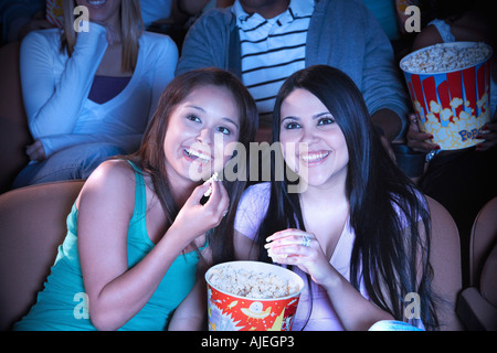 Two young women in the cinema throwing popcorn Stock Photo - Alamy