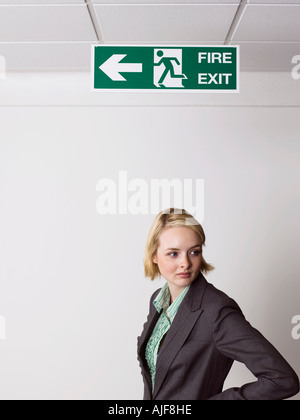 woman standing under exit sign Stock Photo - Alamy
