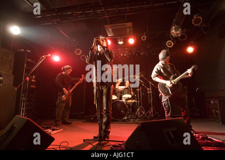 Man in a band singing and playing guitar on a stage at a concert in the ...