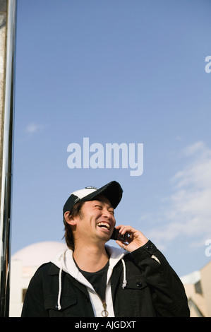 Young man using mobile phone while walking on the beach. Closeup ...