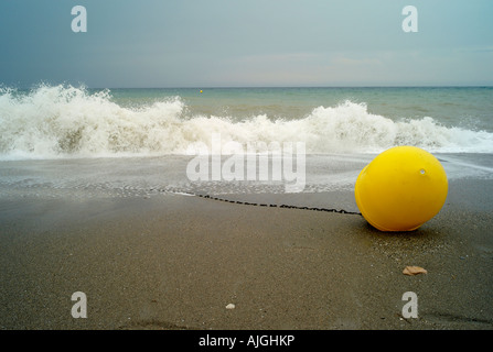 A yellow buoy washed up onto a beach Stock Photo - Alamy