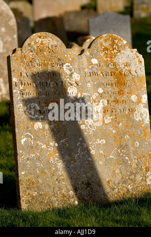 The shadow of cross cast over another gravestone in a Sussex graveyard ...