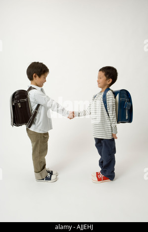 Portrait of two boys shaking hands in therapist office with school ...