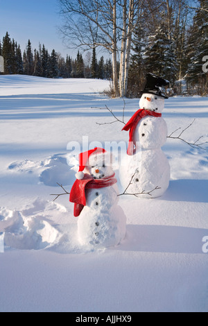Snowmen in forest after making snow angel imprint in snow Alaska Winter ...