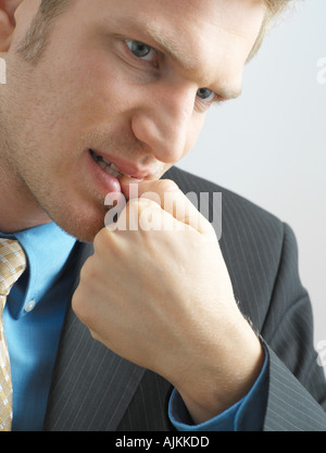 Young man biting thumb Stock Photo - Alamy