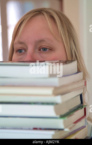 Woman carrying stack of books on the background of a bookcase Stock ...