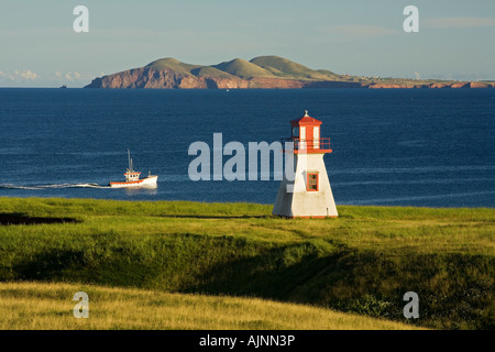 Lighthouse and fishing boat at Cap Alright, Magdalen Islands, Quebec ...