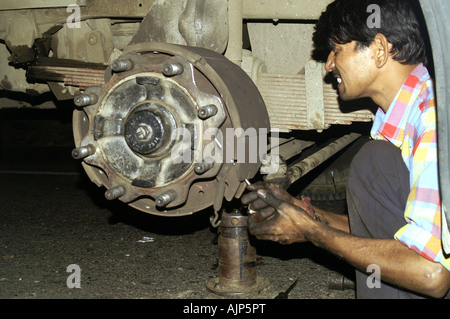 Indian man driver technician repairing broken bus coach wheel burnt ...