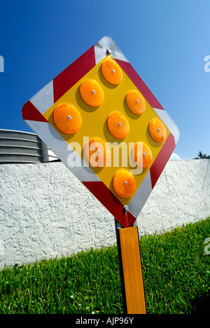 A bright yellow caution sign posted at the exit of a parking garage ...