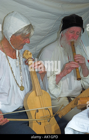 Closeup of two musicians playing medieval woodwind instruments shawm ...