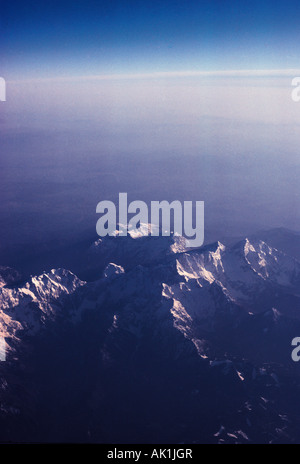 A vertical aerial view of a mountain summit covered with clouds on a ...