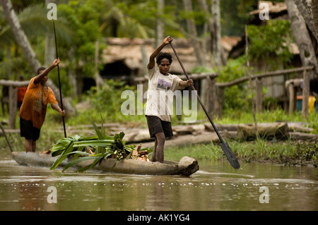 Hunter gatherer Asmat people in a dugout canoe, Irian Jaya Indonesia ...