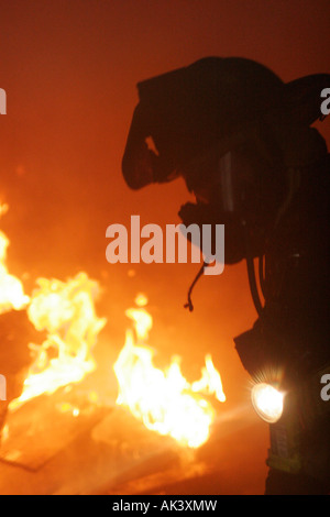 A fire fighter inspecting in a room of fire doing a search and rescue ...