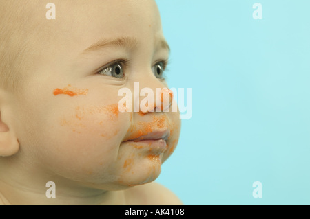 A baby with his face smeared with baby food Stock Photo - Alamy