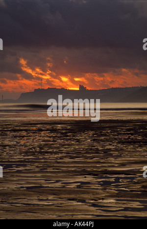 View from Sandsend of Whitby Abbey and harbour, as the last of the sea ...