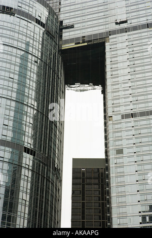 A glass building wall with window washers descending the facade on a ...