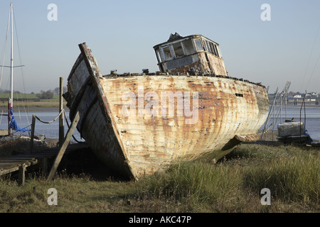 A wooden decaying derelict boat out of the water by a river Stock Photo ...