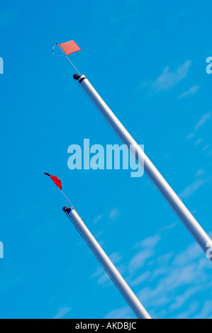 Mast of sailing boat with a red burgee seen against a blue sky at ...