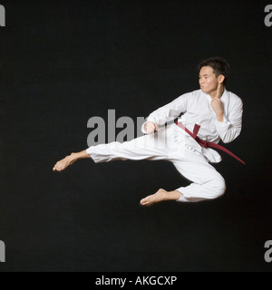 Young man performing flying kick Stock Photo - Alamy
